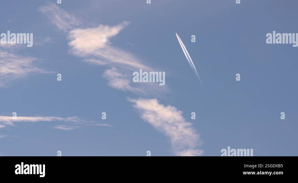 Airplane flying overhead jet stream contrails blue sky and clouds Stock ...