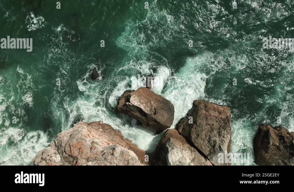 aerial top down revealing rock cliff geologic formation and blue ...