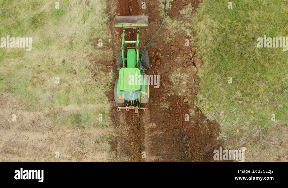Top Down View Of Green Tractor Pipe Laying Irrigation Pipeline On Farm ...