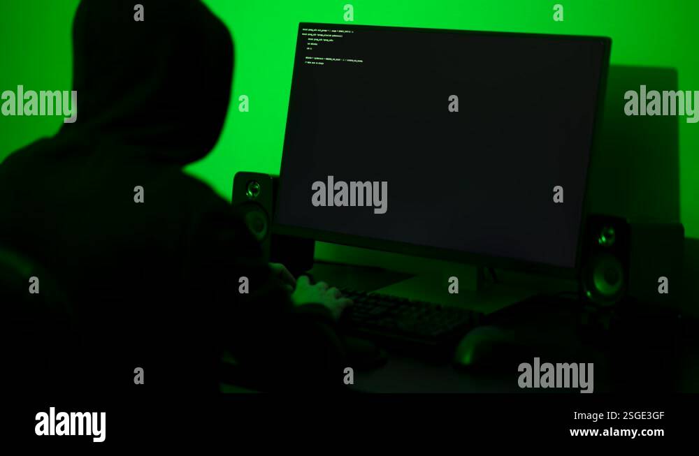 Hacker typing fast on a computer keyboard in a dimly lit room. Medium ...