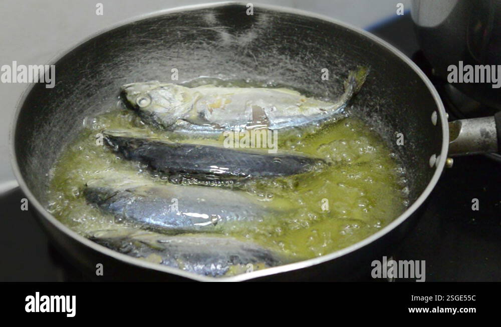 Cook the fish are fried in pan on asian stove Stock Video Footage - Alamy