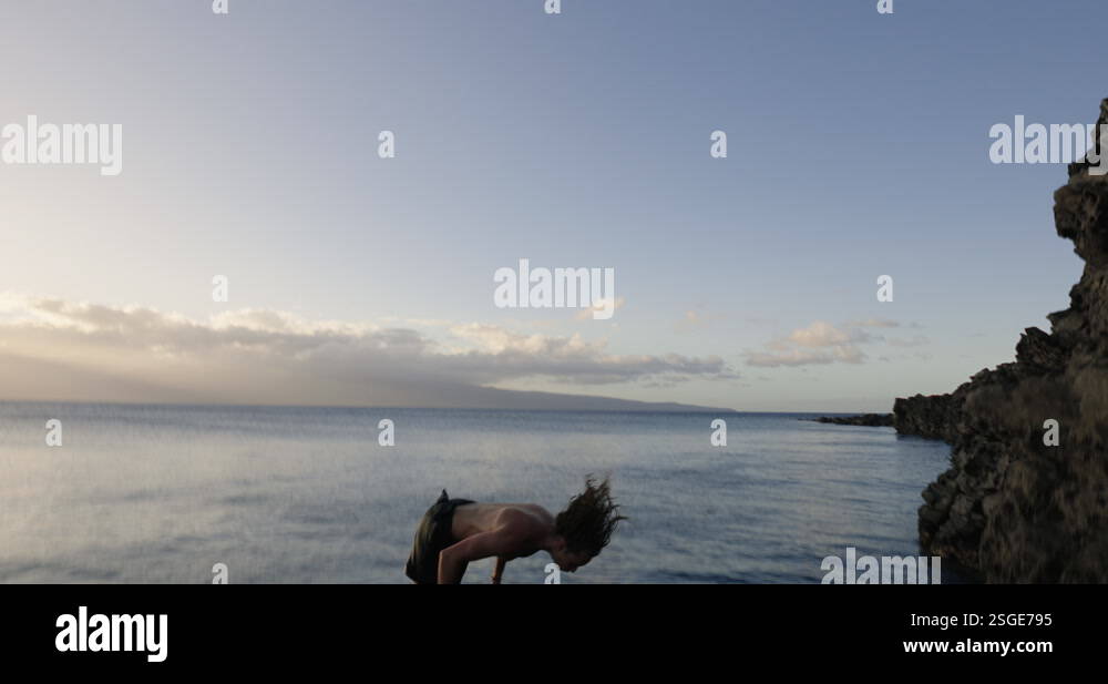 Young man extreme cliff jumping backflip into the ocean Stock Video ...