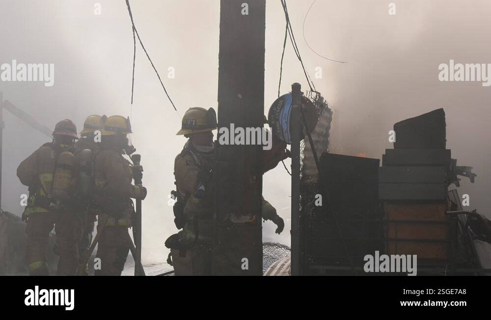 firefighters spray building that caught fire Stock Video Footage - Alamy