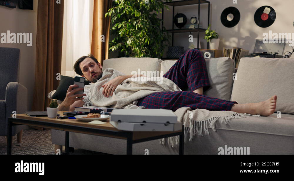 A man wakes up in the morning on a couch in a man's living room. The ...