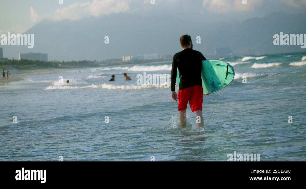 A retired athlete enters the sea, goes to ride on the waves on surfing ...