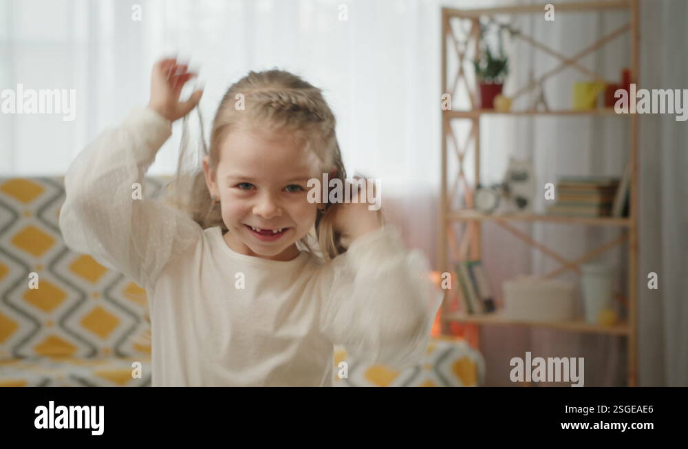 Kid girl has fun making ears with hands and fumbling hair. Preschooler ...
