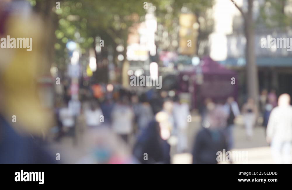 Blurred background of daytime shoppers walking around a town centre, in ...