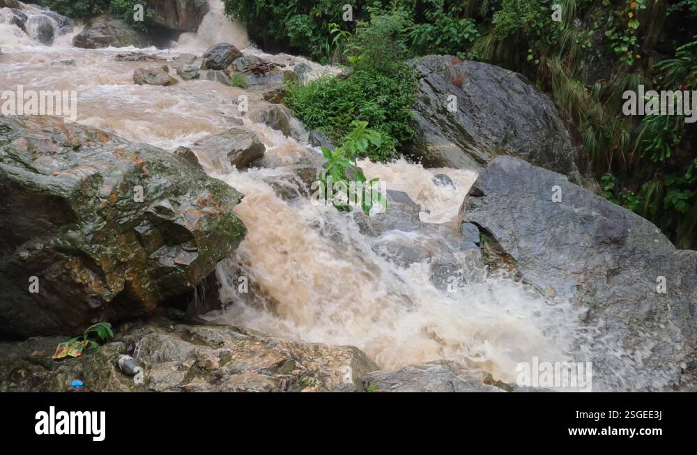 Water raging over the rocks of a waterfalls in the hills of Nepal ...