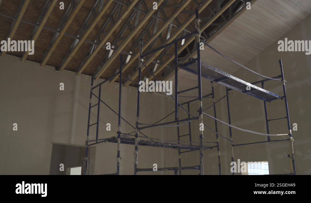 Blue scaffolding inside a steel frame house under construction. No ...