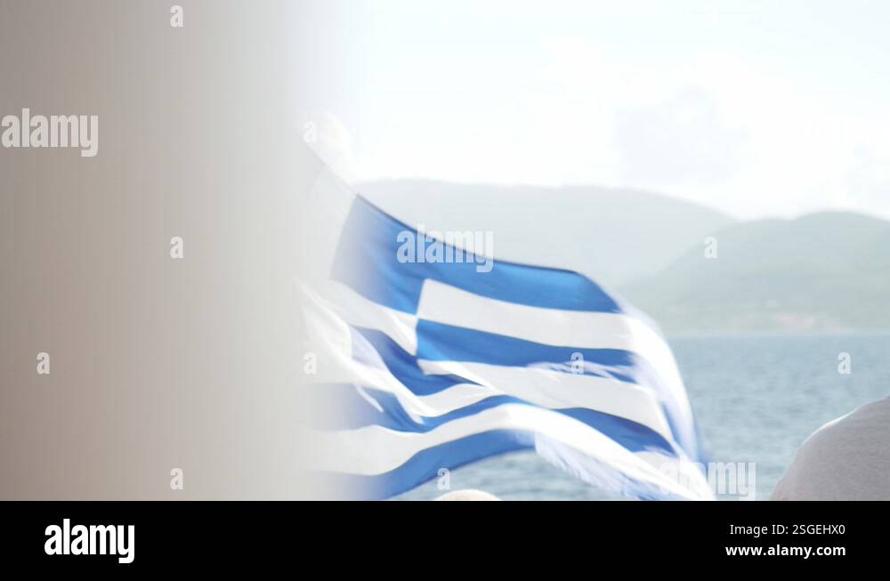 The Greek flag floating in the wind above the Aegean sea with the Stock ...