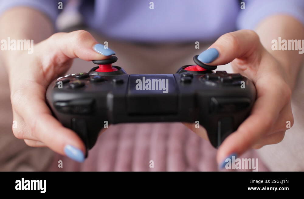Woman playing video games using wireless controller. Close up of hands ...