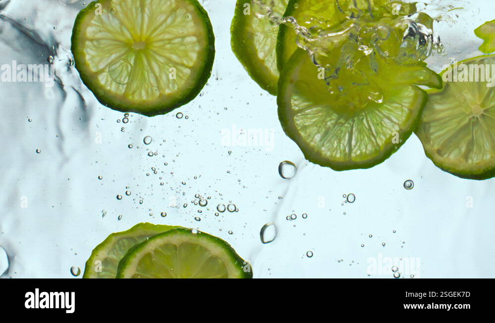 Citrus pieces floating water in super slow motion close up. Lime dropped liquid Stock Video ...