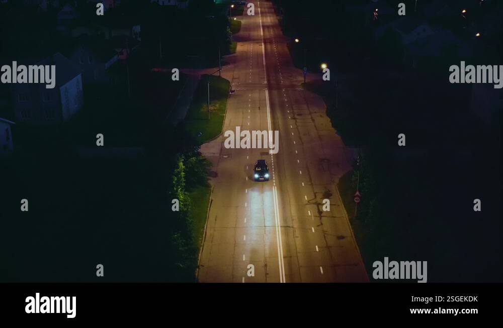 The car passes a speed bump on a city street at night, suburban, summer ...