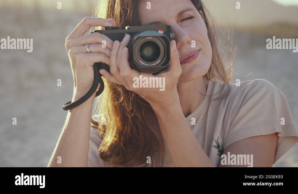 Female photographer. Woman photographer takes pictures outdoor with ...