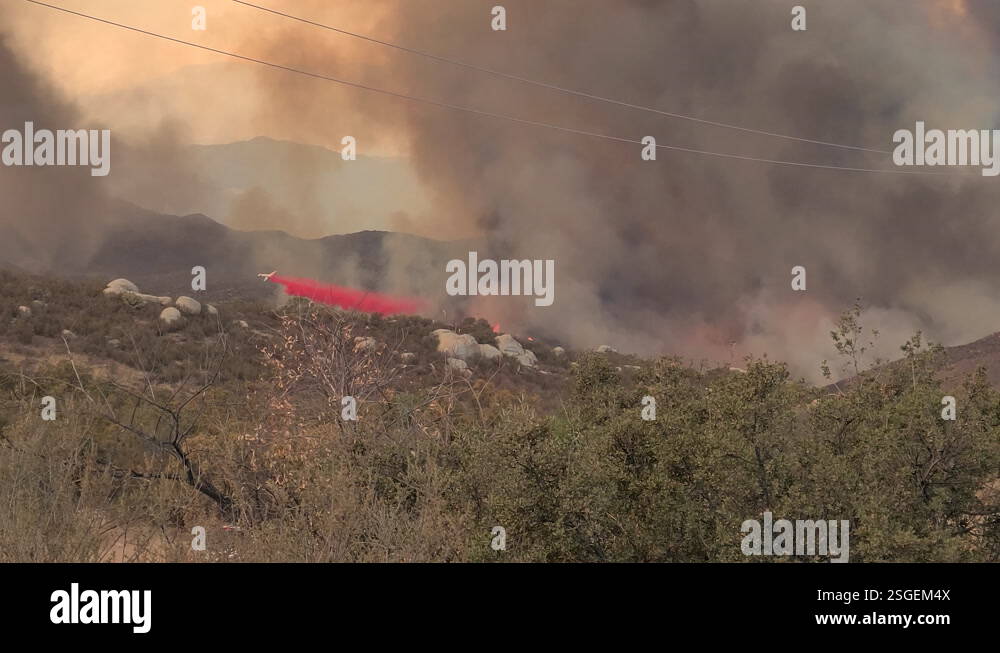 Airplane Drops Red Fire Retardant on Wildfire in California, distant ...