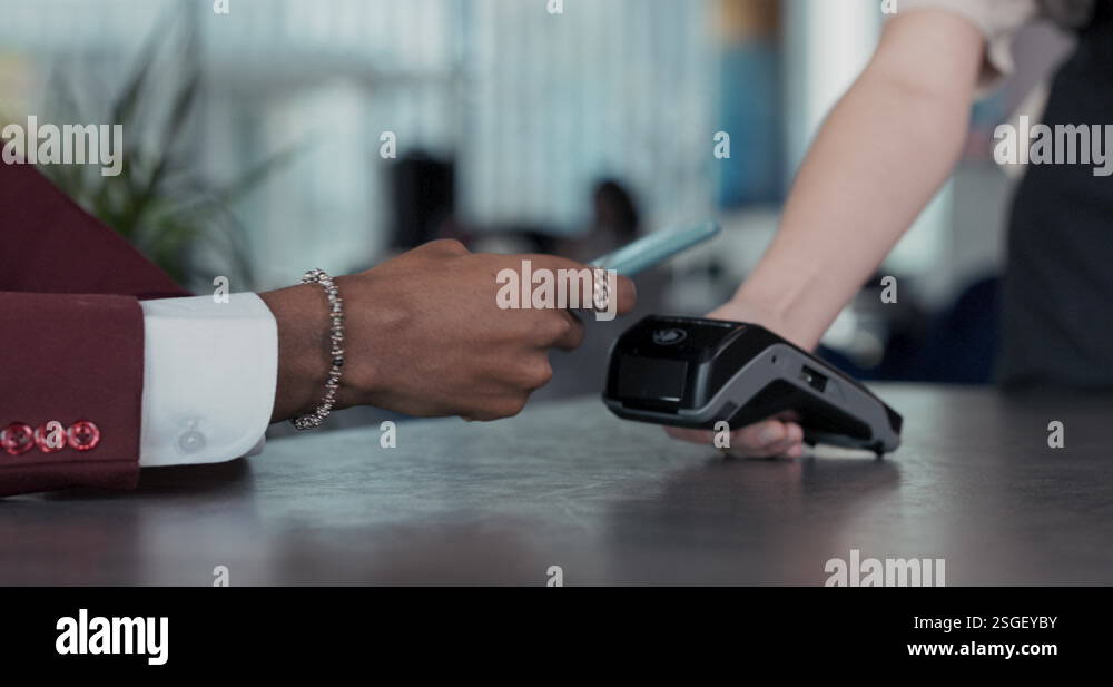 Close-up of a man's hand paying with his phone for an order at a ...