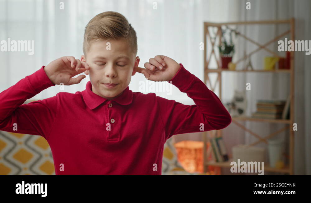 Boy rolls eyes and covers ears with fingers shaking head. Irritated ...