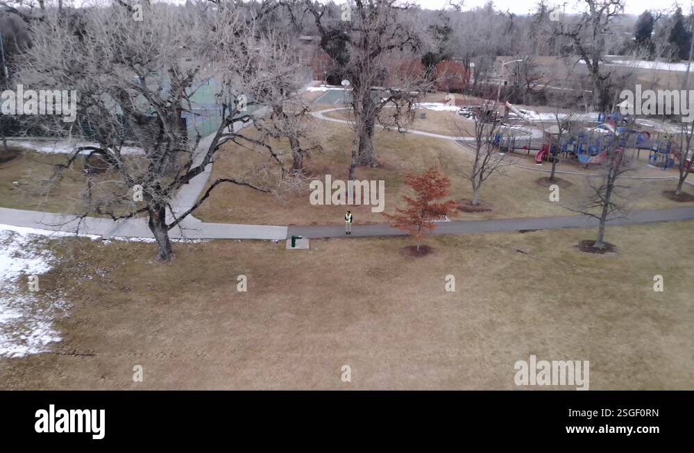 Man at Park Flying a Drone on a Fall Day • Aerial Drone Push Out Shot ...