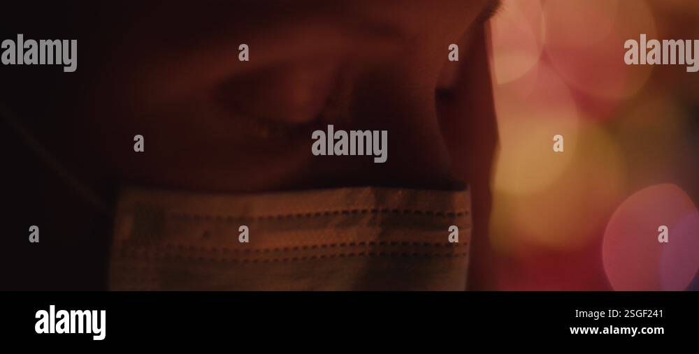 Woman in face mask mourns cry sad eyes in close up night at cemetery ...