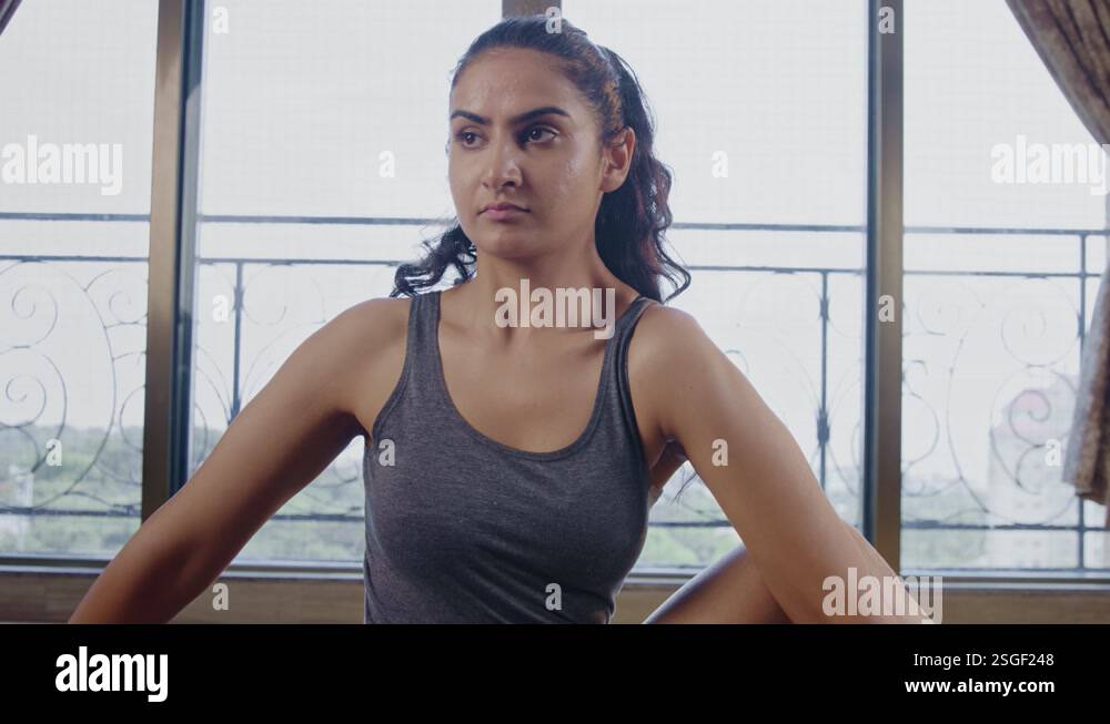 Young Indian Woman performing yoga posture Ardha Matsyendra Asana in ...