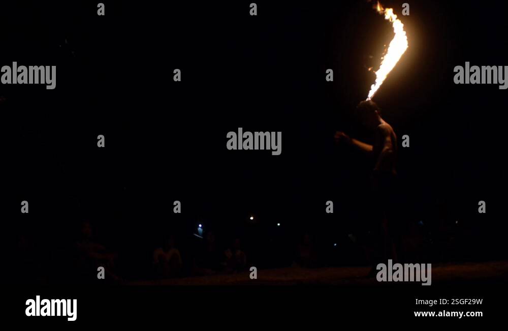 Caucasian man spinning fire rod during fire dancing ceremony, filmed in ...