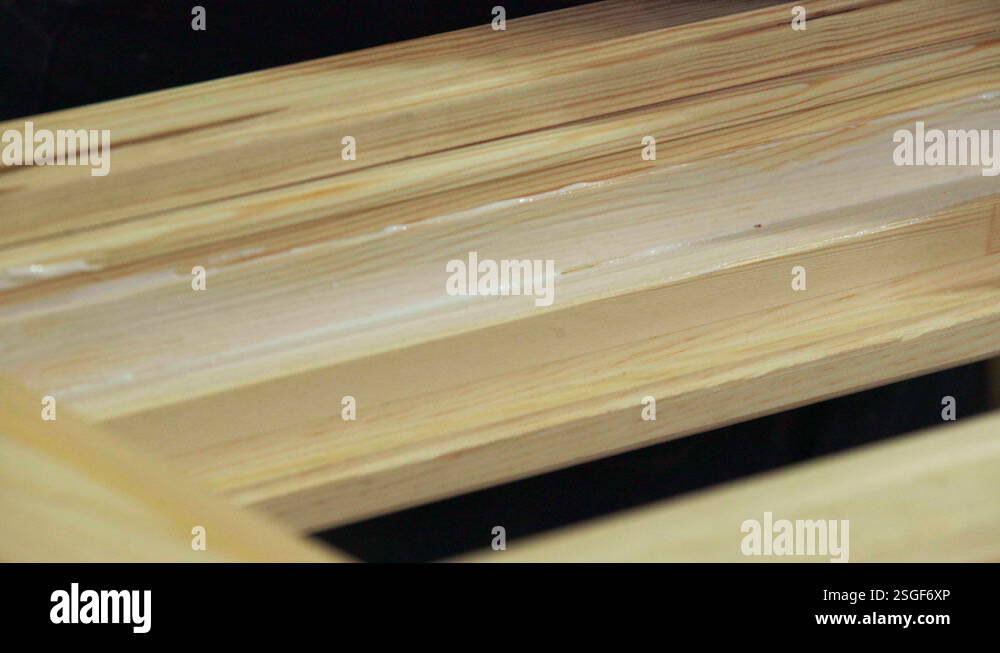 Creating a handmade window by glueing multiple timber planks at the ...