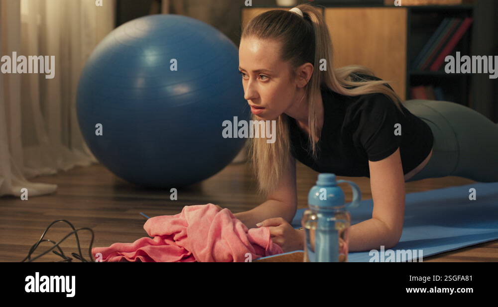 Slim fitnes young girl with ponytail doing planking exercise indoors at ...