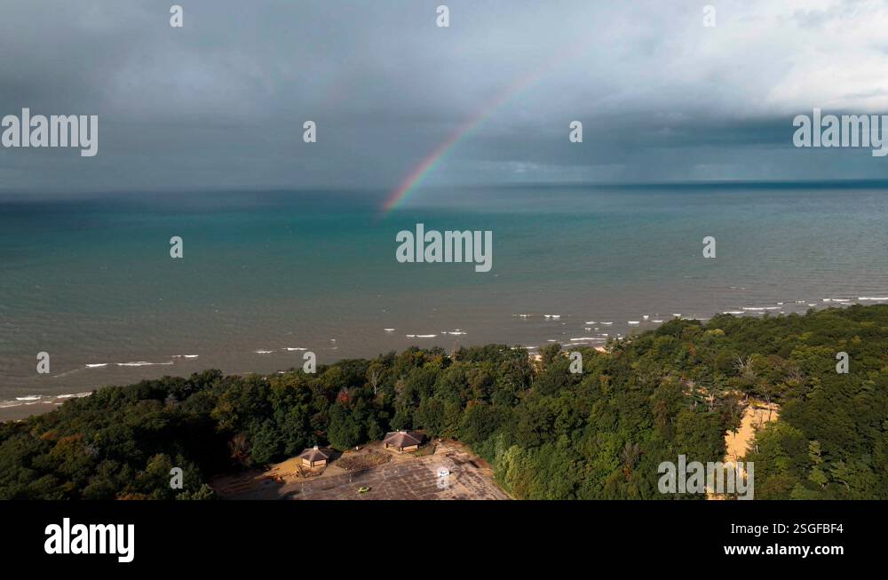 Rotating around a Rainbow over the shallow cliff of shores on lake ...