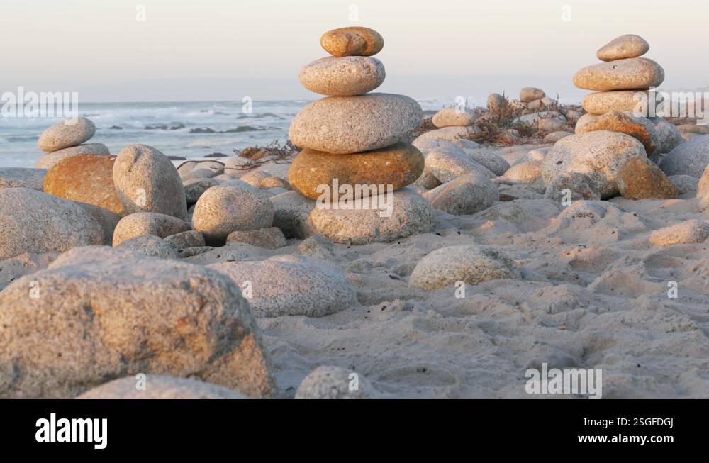 Rock balancing on pebble beach. Pyramid stacks of stones, ocean coast ...