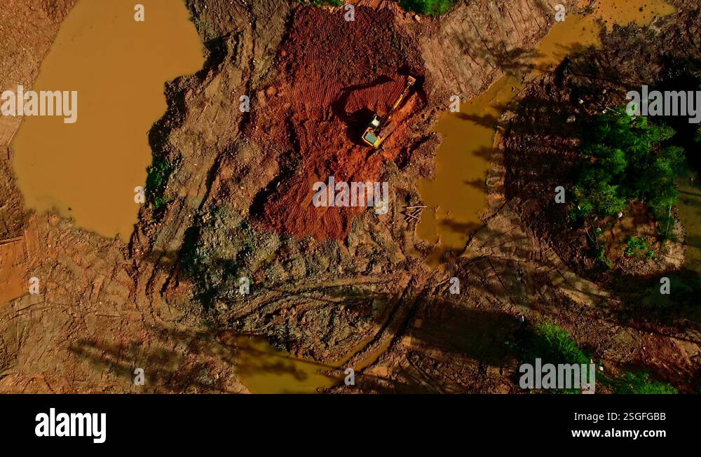 Bulldozer excavator on muddy and marshy ground in forest. Aerial top ...