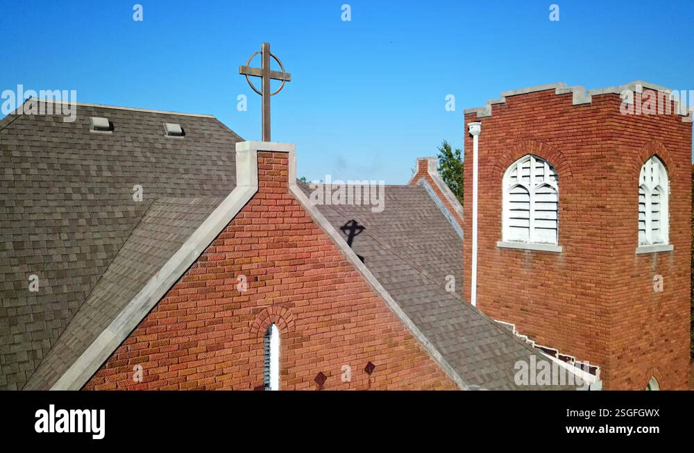 Beautiful redbrick church on sunny day. Backwards revealing trees and ...