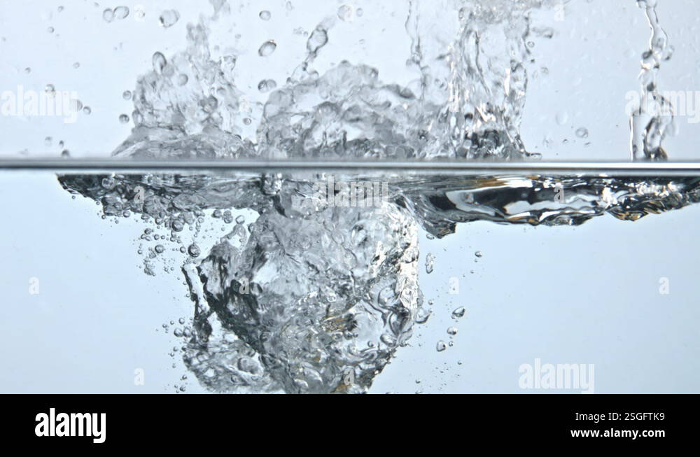 Pear splashed fizzy water closeup. Fresh yellow fruit fall under ...