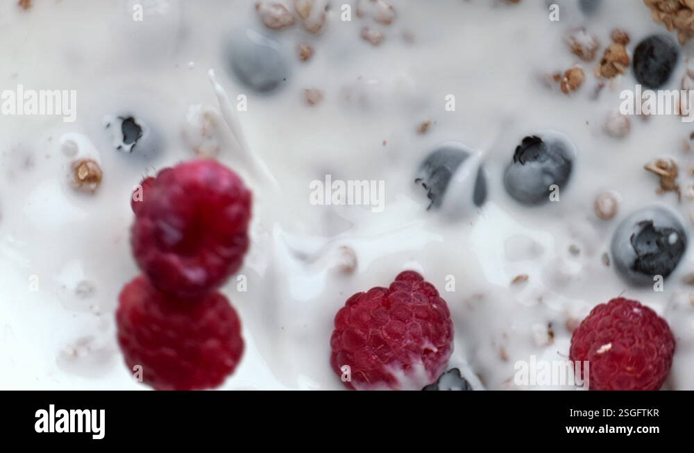 Raspberry throwing splashing yoghurt top view. Calcium oat liquid with ...