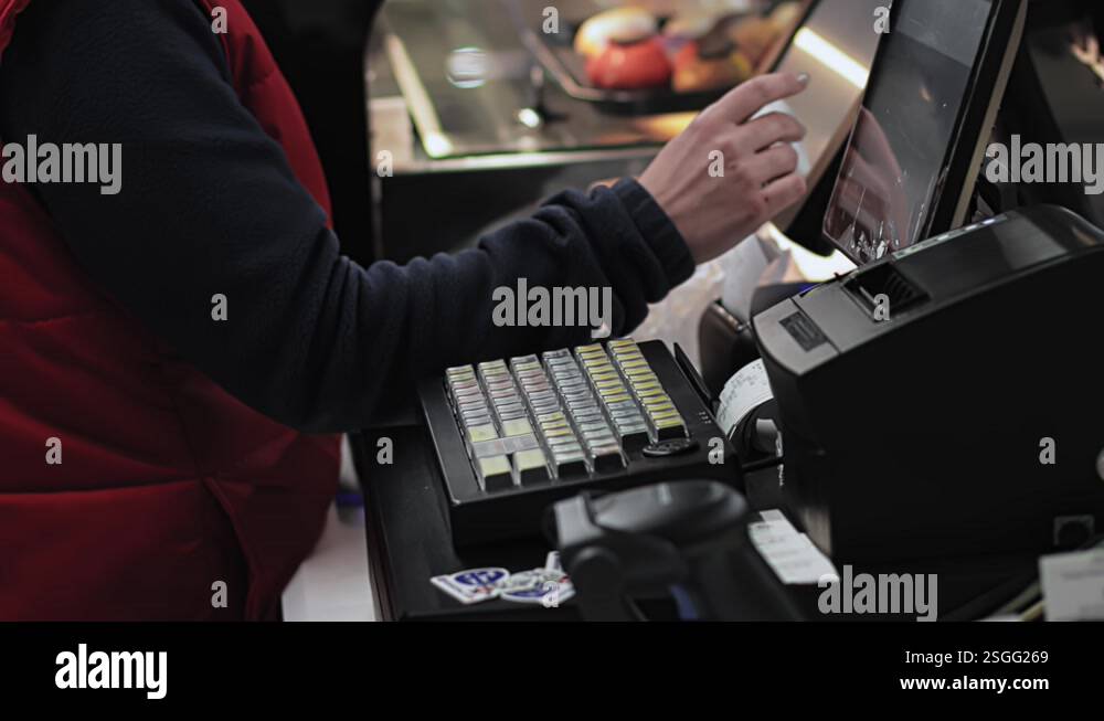 Female cashier tears receipt from cash register. Shopping at mall and ...