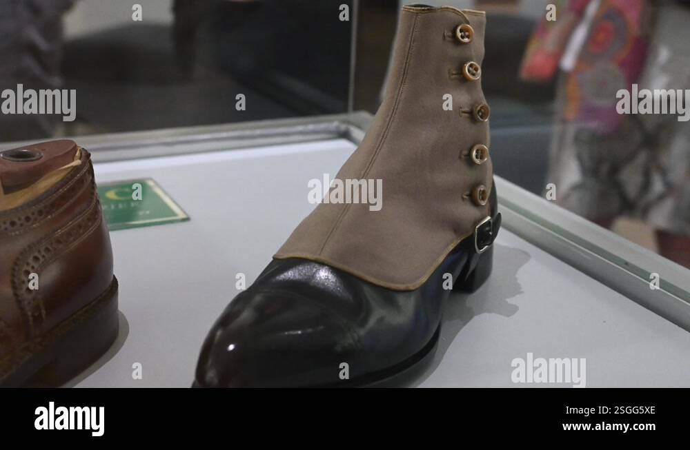 brown boot with buttons on the side, behind the showcase of a fashion ...
