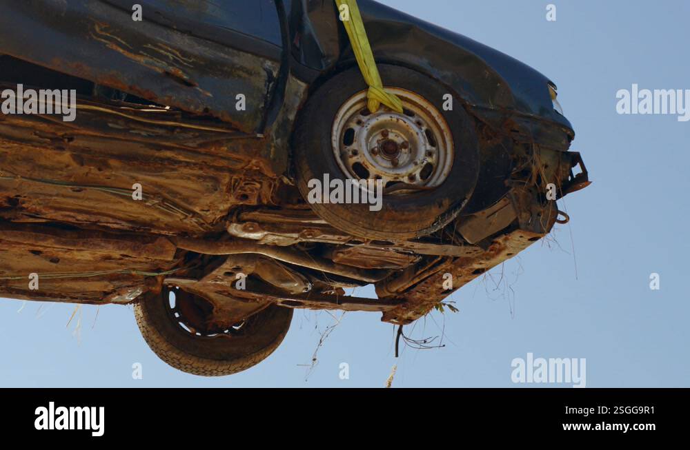 Wrecked car lifted in air with crane strapped on wheels, view from ...