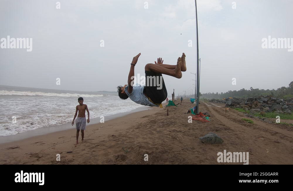 a teenage boy somersaults on the beach. free exercise. 4K videos ...