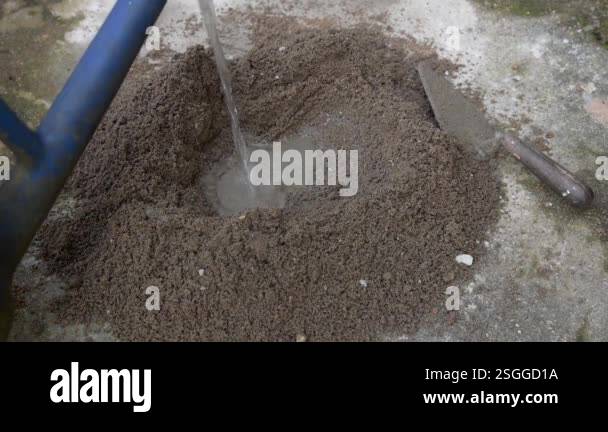 adding water to mortar or cement mixture, rough, granular texture of ...