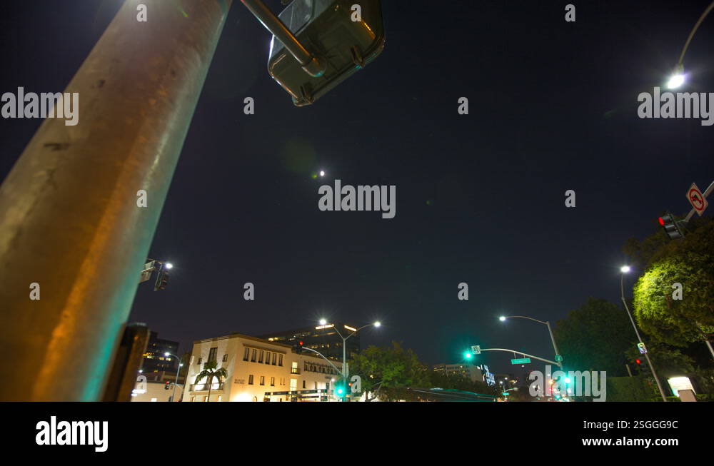 Tilt Up Time Lapse Shot Of Sign Board On Traffic Signal By Road In City ...