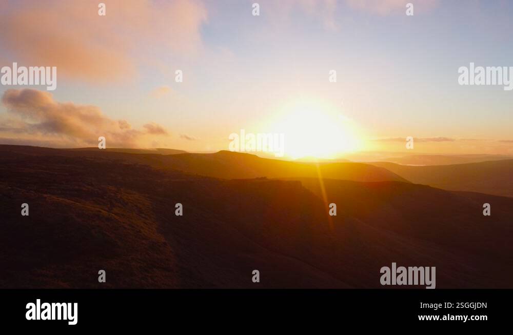 Sunbeam shining behind mountain range during golden sunset - drone shot ...