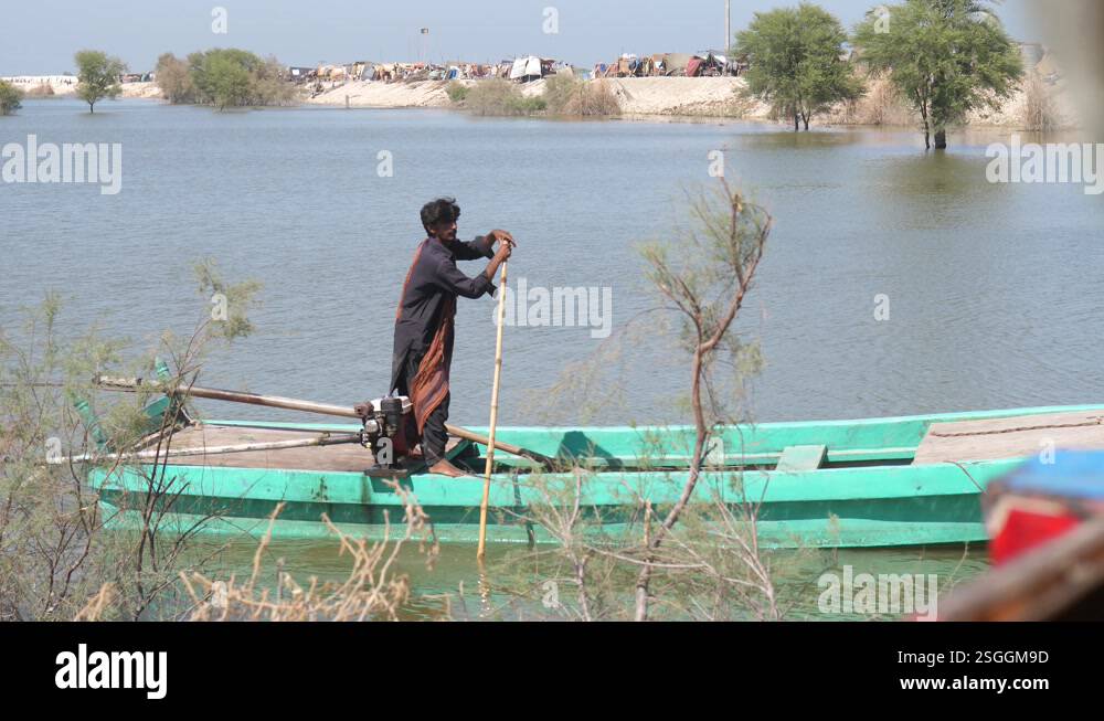 Male Using Long Stick To Row Past On River In Green Boat In Maher ...