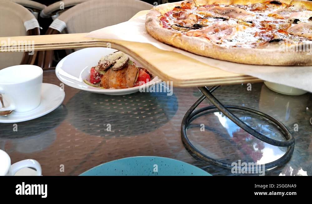 pizza cooked in an italian restaurant. Close-up ham meat onion pizza at ...