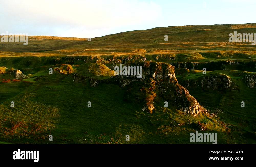 Aerial view of couple visiting the green hills of Fairy Glen in ...