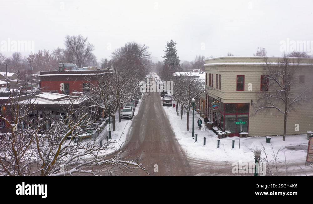 Aerial view of a small town with snow actively falling on its quaint ...