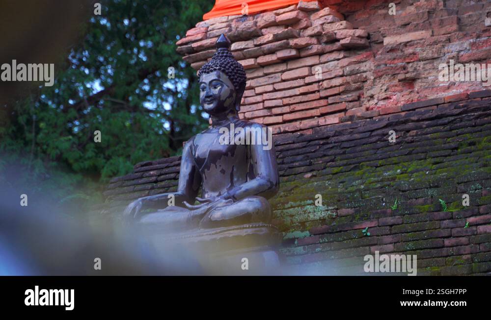 Sliding reveal of Buddha Statue against stone temple walls in Thailand ...