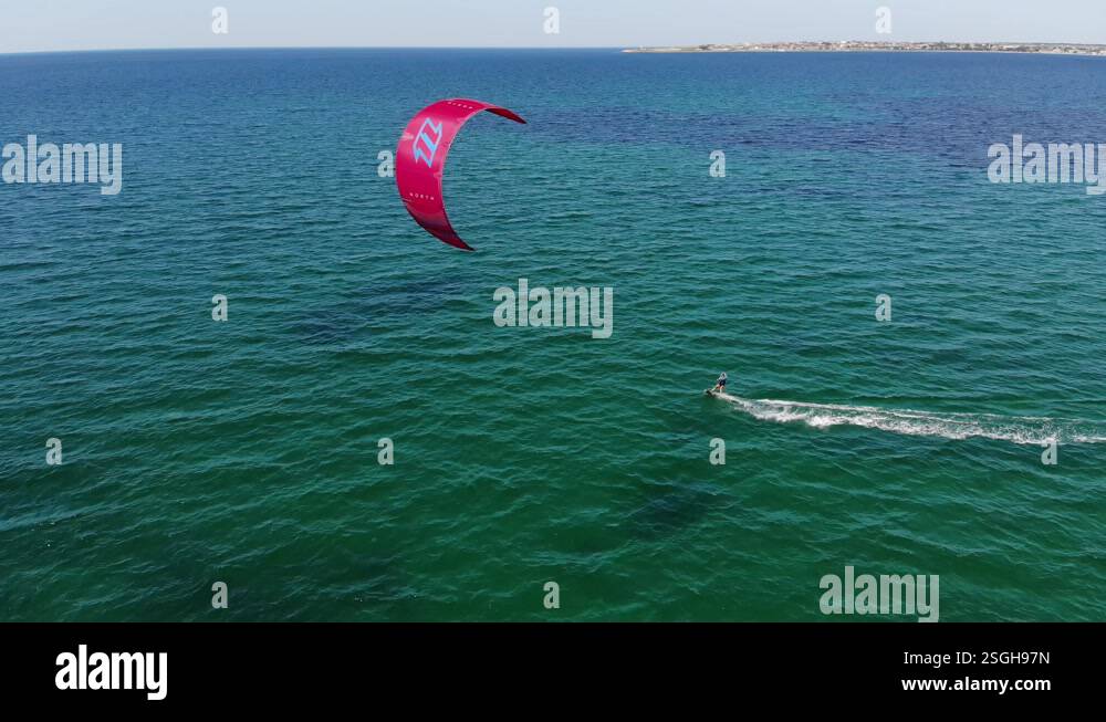 Aerial view of a young caucasian sportswoman cruising on her kitesurf ...