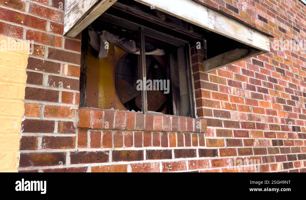 Abandoned dilapidated small old retail strip mall window fan and brick ...