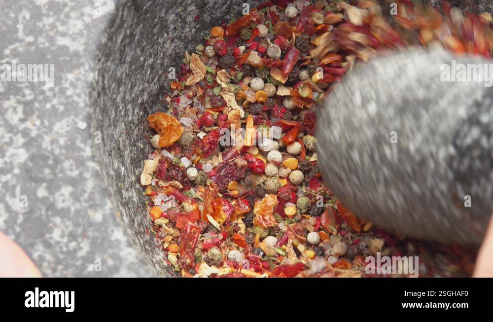 The pestle crushes the mixture of peppers Stock Video Footage - Alamy