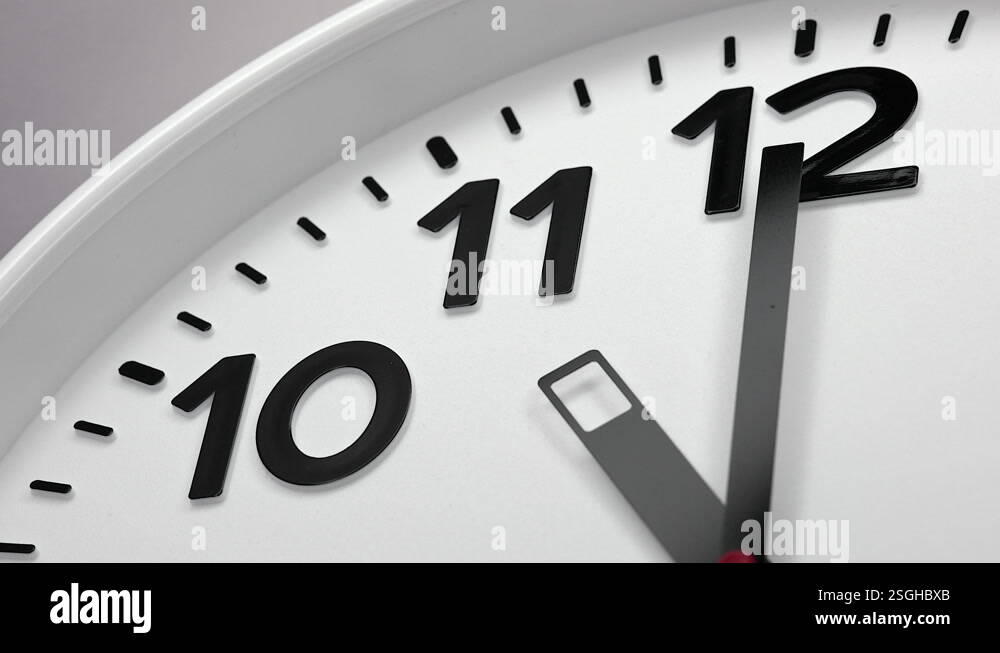 A White Wall Clock With The Time Of 11.00 Am Or Pm. A Black Hands and ...