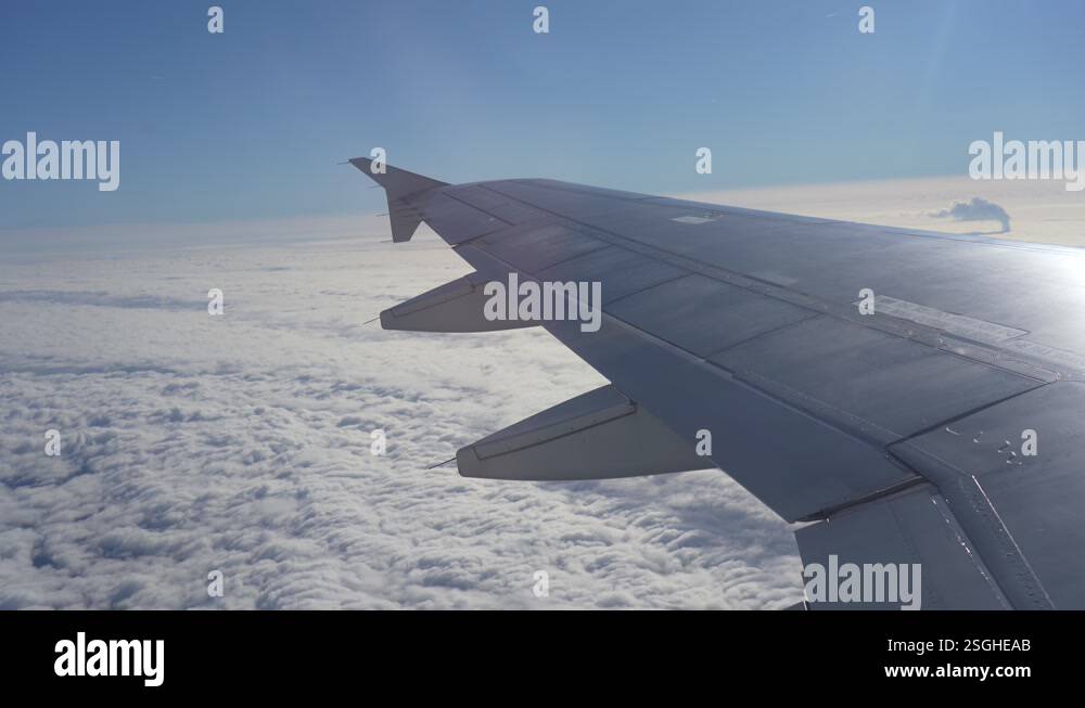 Airplane view through onboard window during flight above blue sky with ...